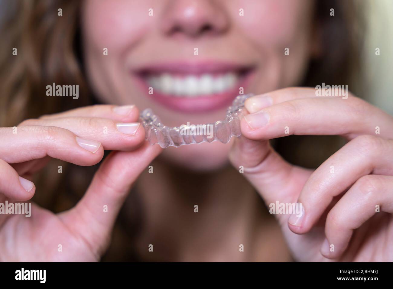 Young woman smiling showing her invisible ortodonthics Stock Photo - Alamy