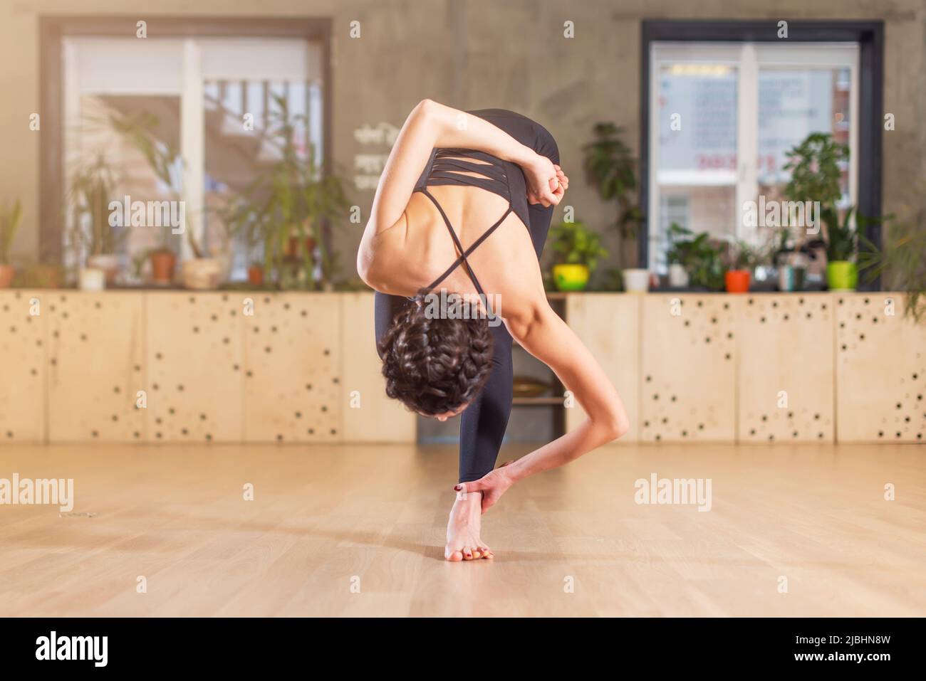 Woman doing yoga, exercising, training in gym stretching bending ...