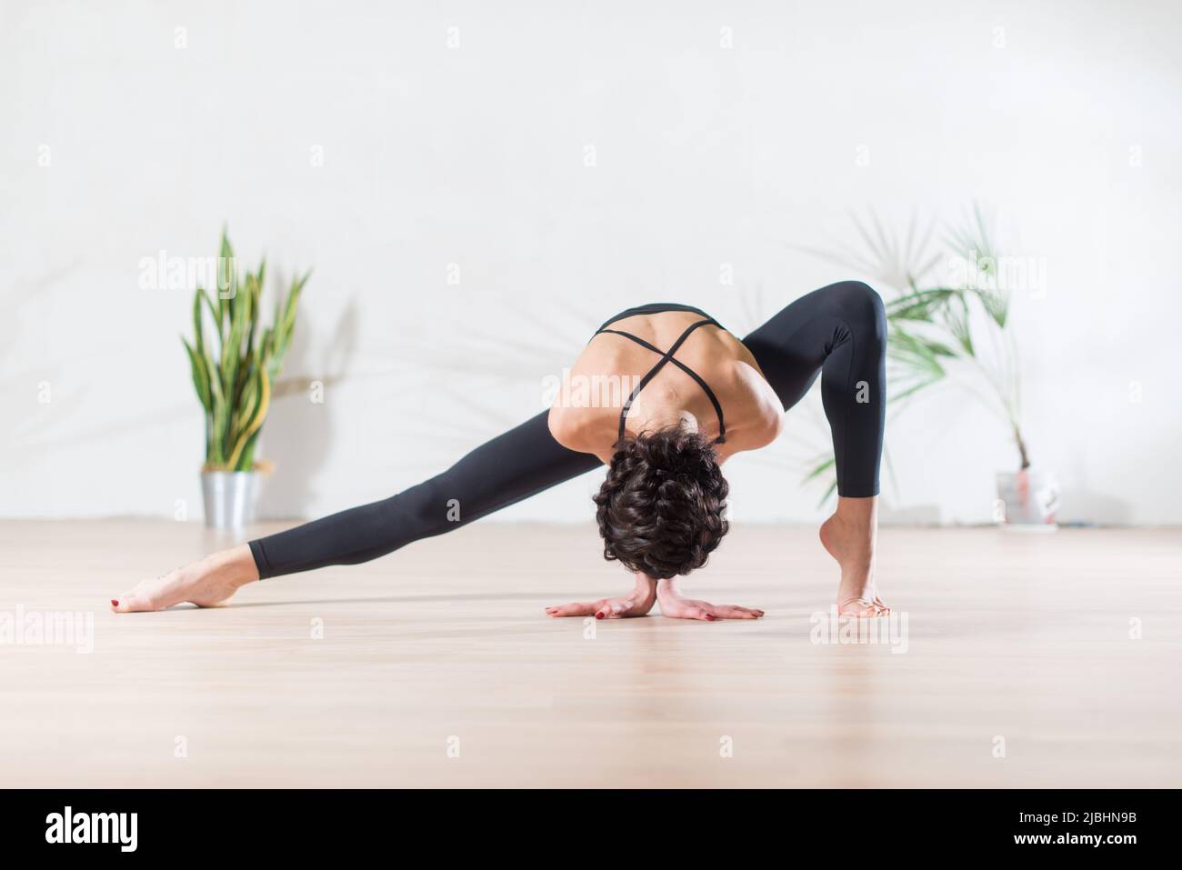 Fit modern dancer standing gracefully on tiptoe in wide side lunge ...