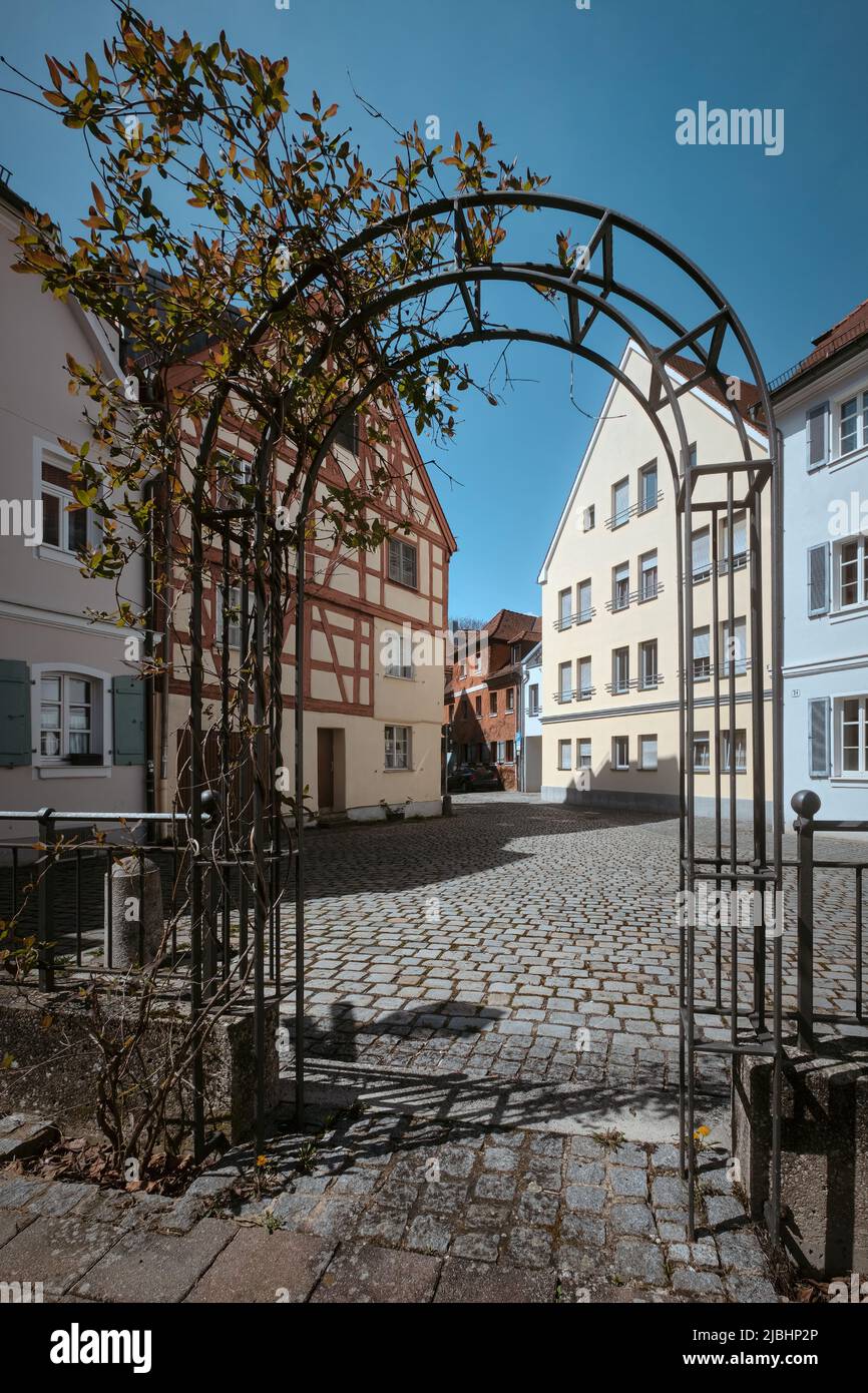 View in the old town of Ansbach. Iron gate in the shape of an arch with ...