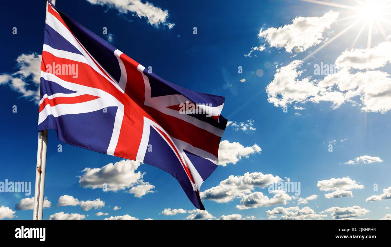 UK, United Kingdom, Union Jack flag waving in sky Stock Photo - Alamy