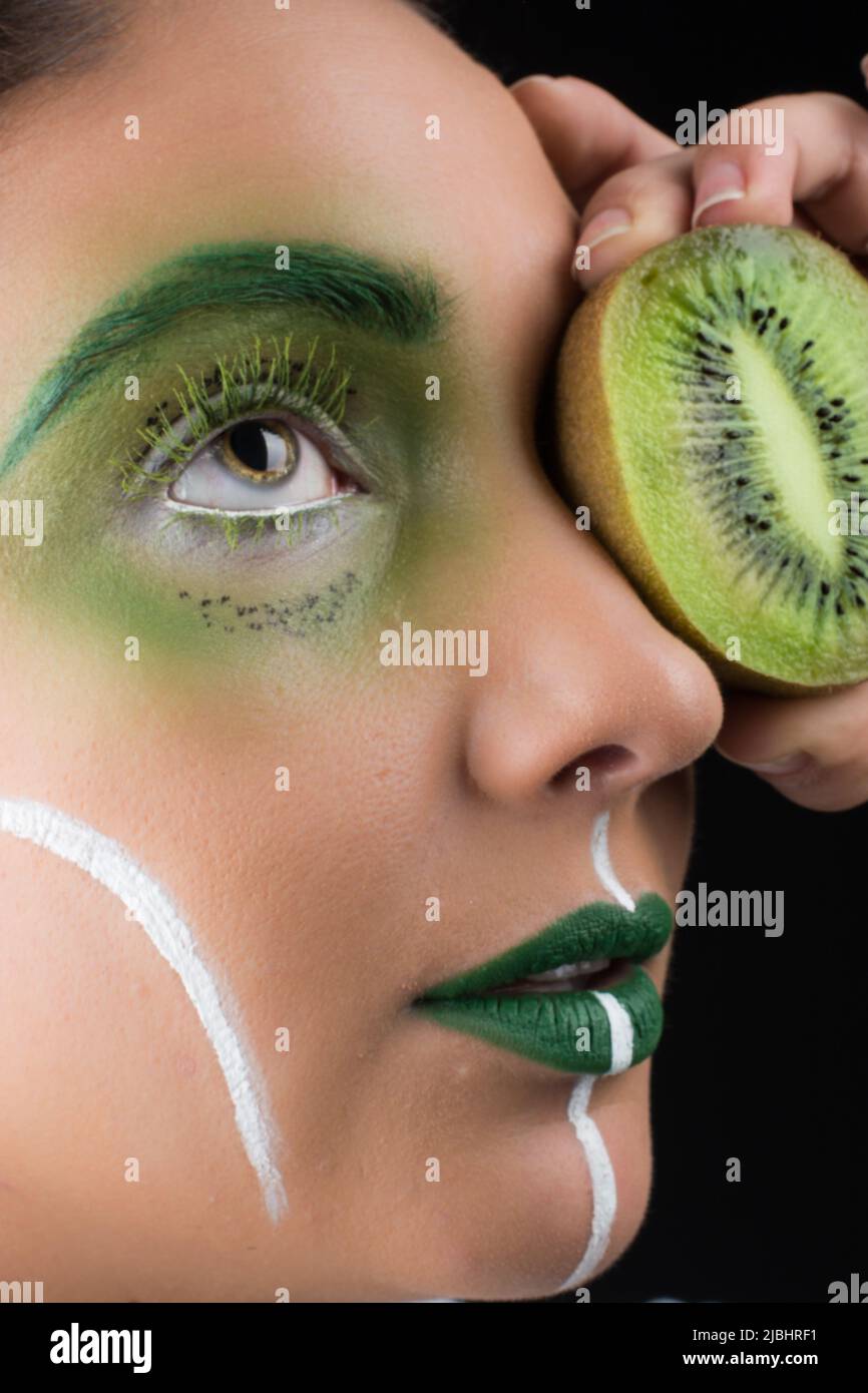 Fantasy makeup portrait of a woman kiwi eye and green lips on black ...