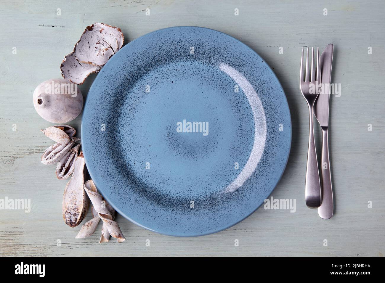 Empty blue plate and exotic spices and fruits on light blue wooden ...