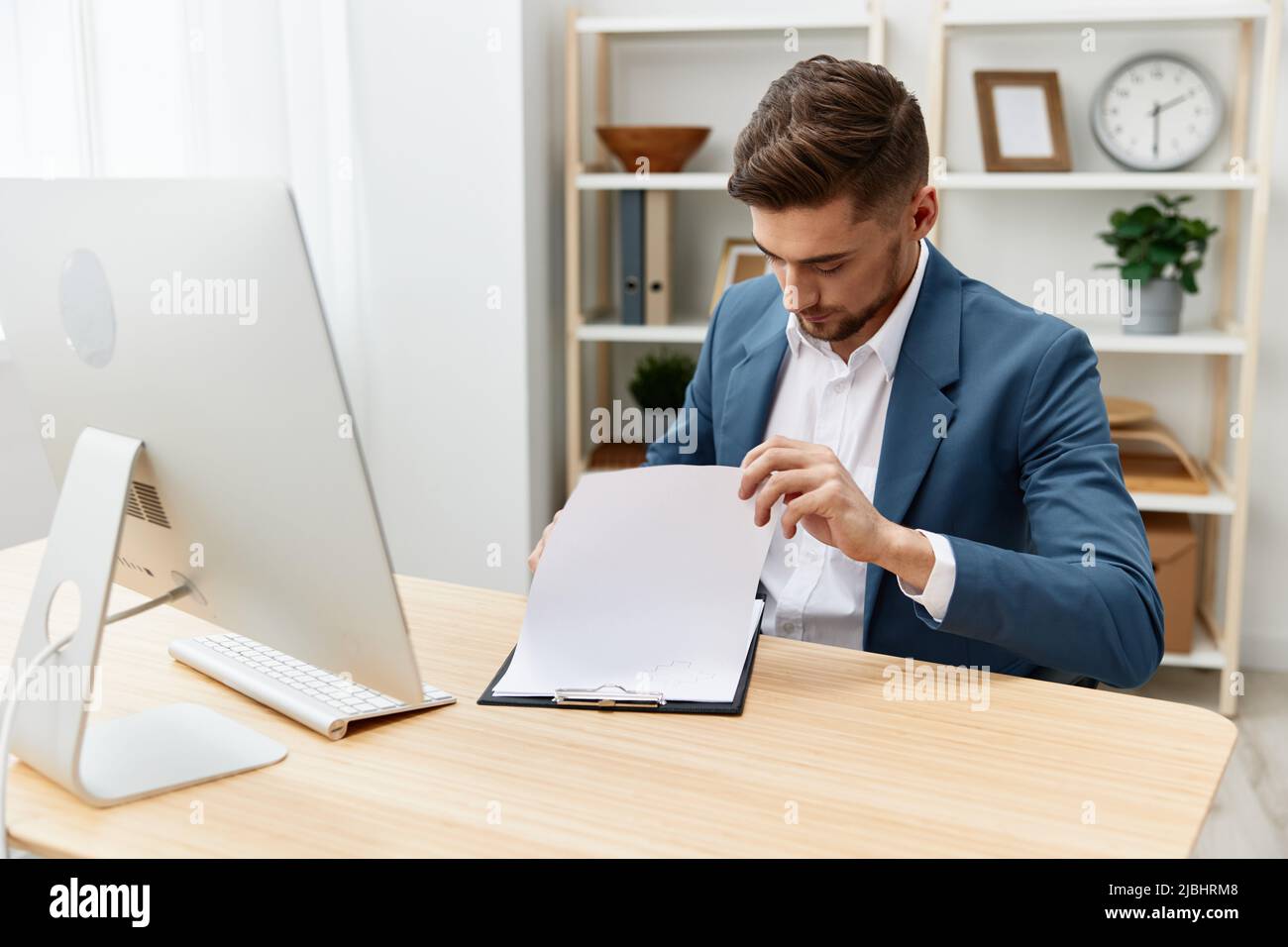 manager writes in documents at the desk in the office isolated ...