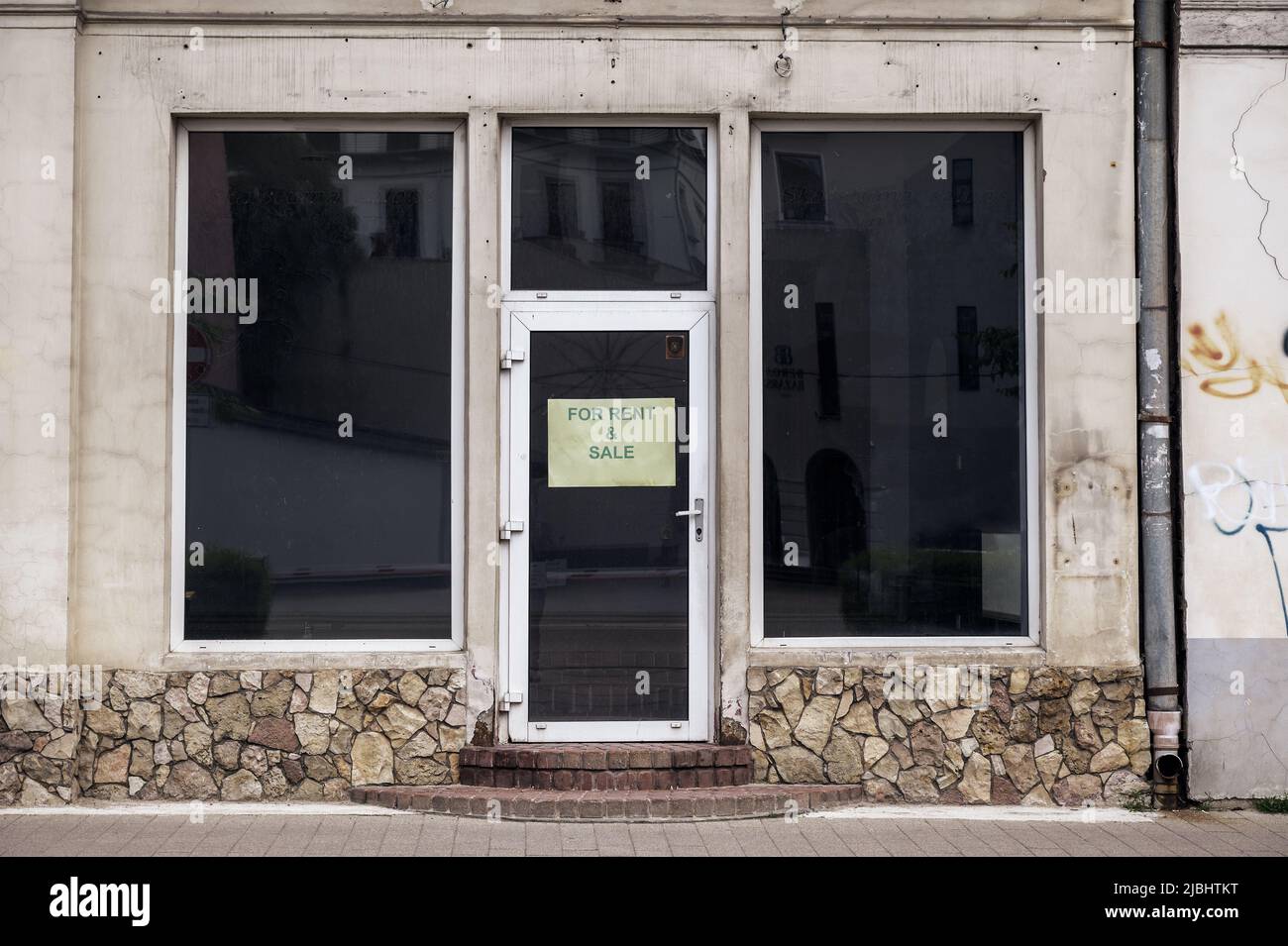 Closed bankrupt store. Empty glass showcases. The sign on the door is ...