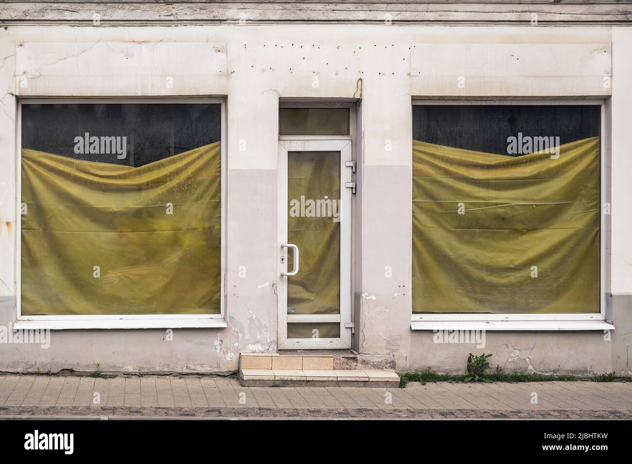 a bankrupt store with film-covered windows. Empty store front economic ...