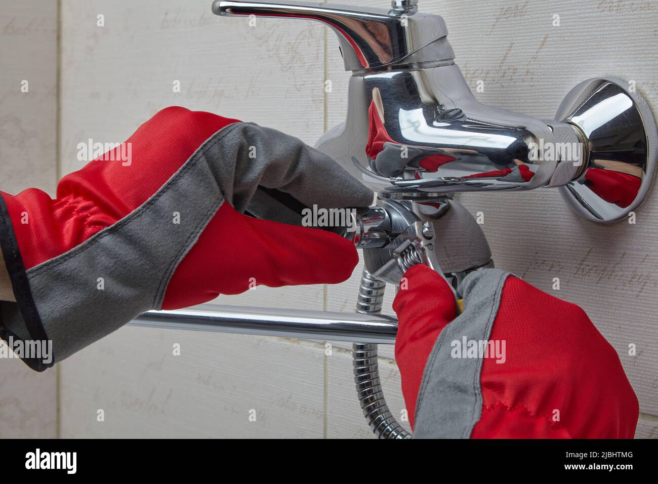 Replacing a worn out shower valve switch. Plumber's hands in work ...