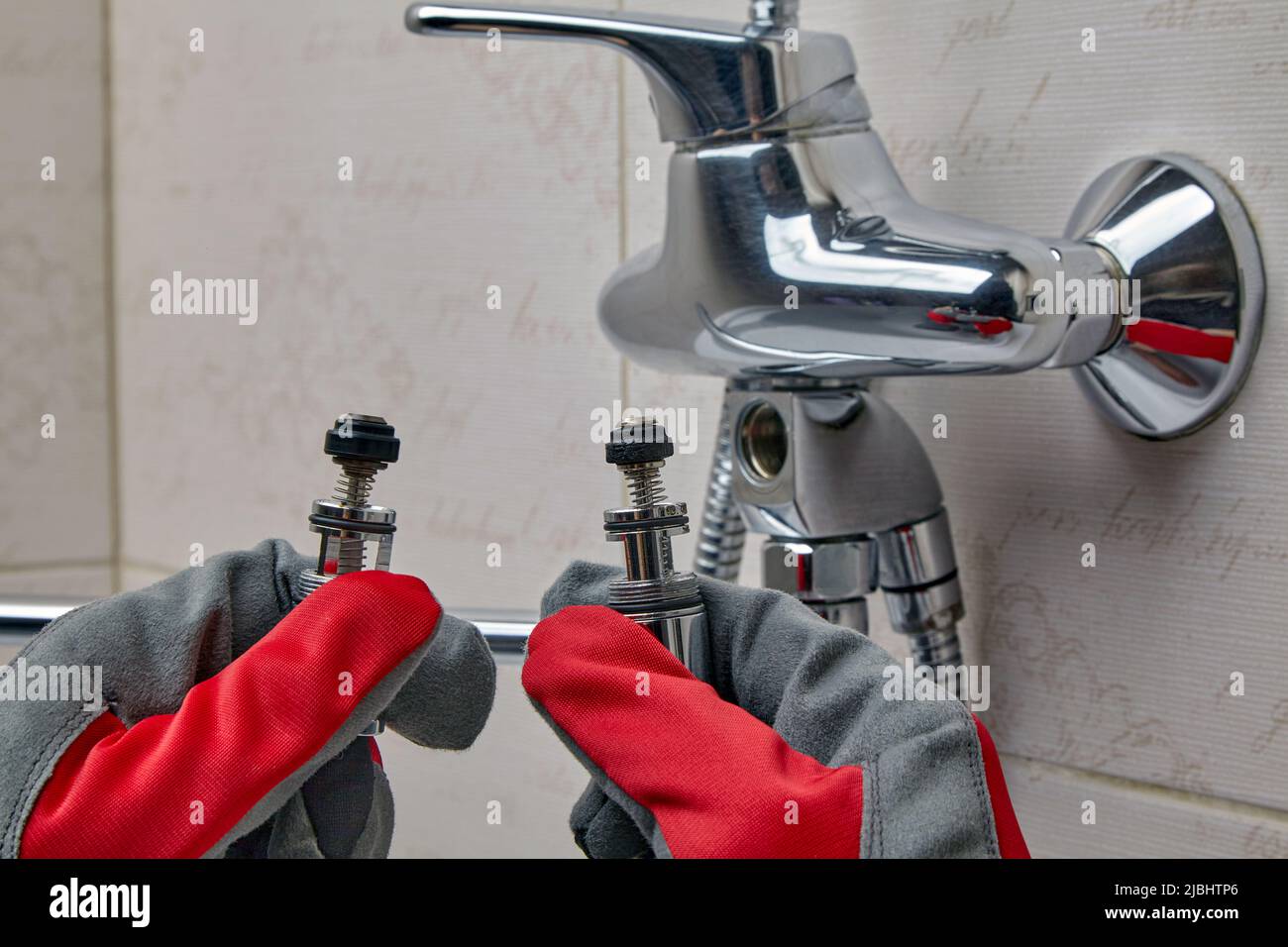 Repair of the plumbing switch of the shower valve. Plumber's hands in ...