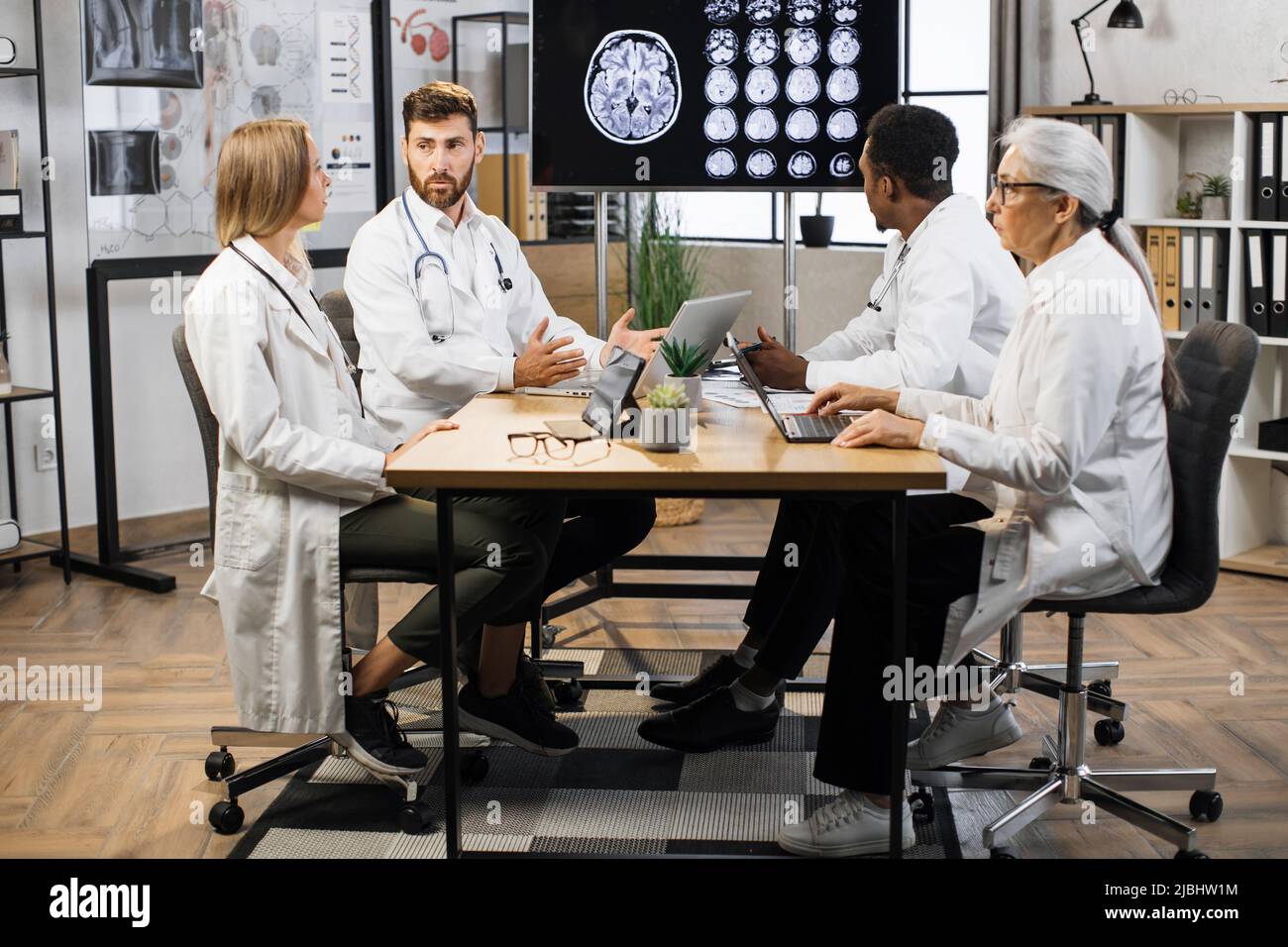 Team of international medical experts sitting at table and analyzing ...