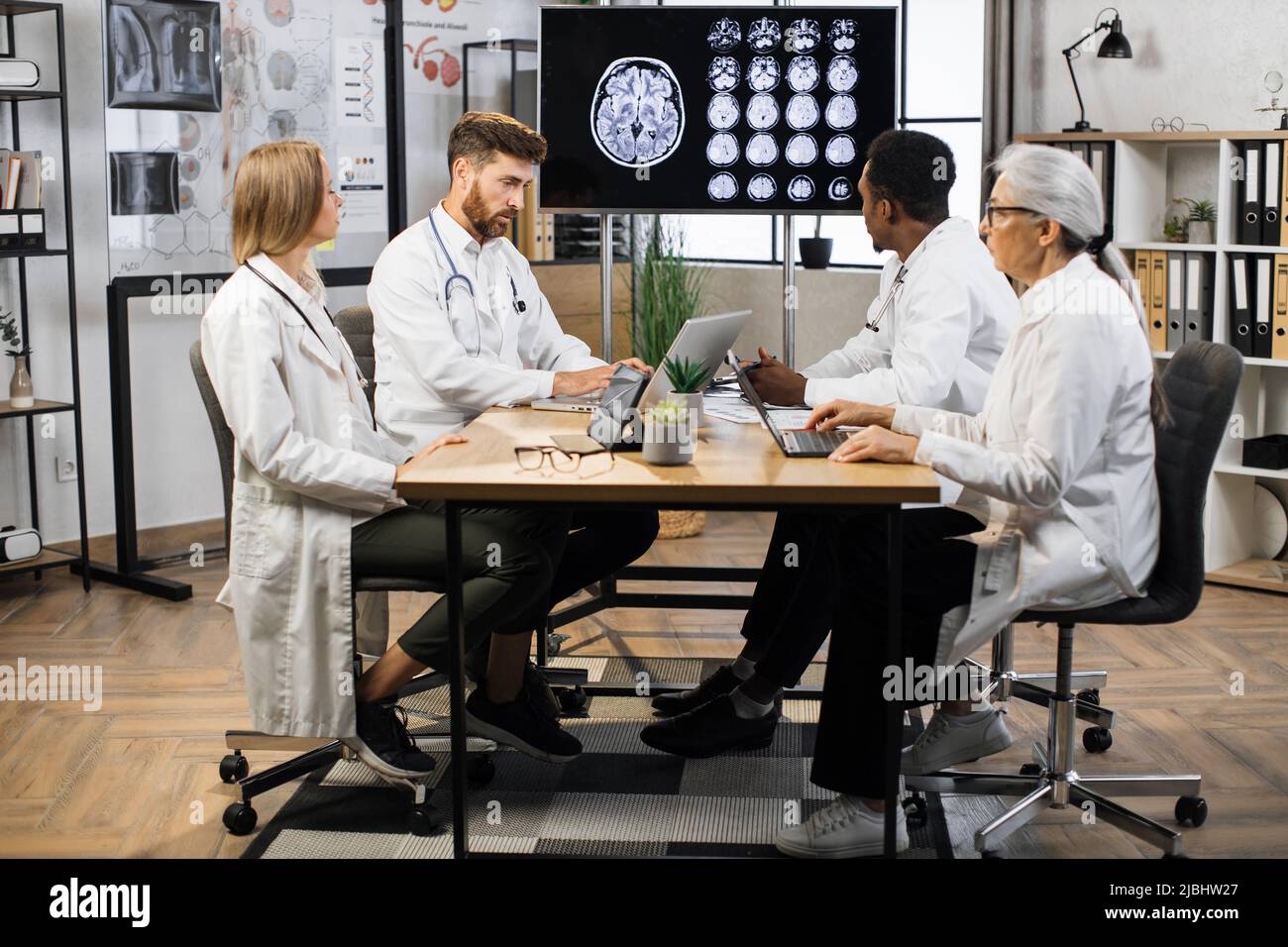 Team of international medical experts sitting at table and analyzing ...
