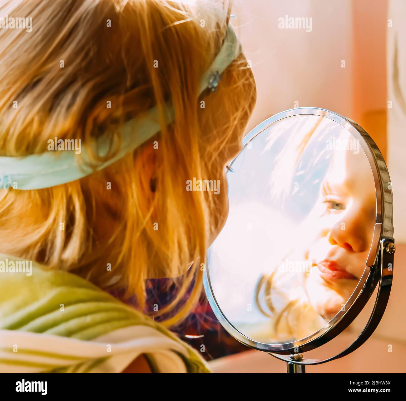 Little girl looking at the reflection in the mirror Stock Photo - Alamy