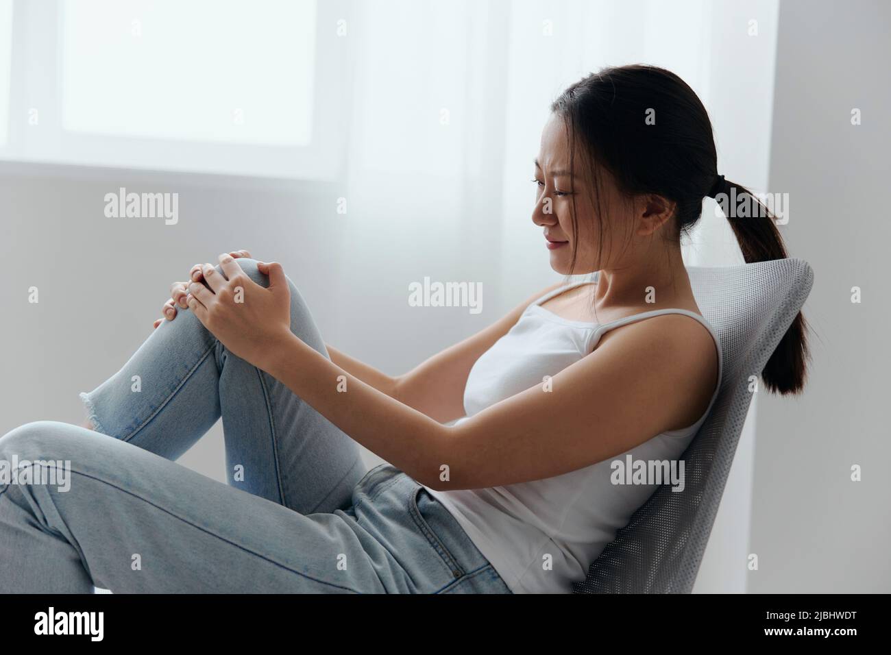 Unhappy sad suffering tanned beautiful young Asian woman touch injury ...