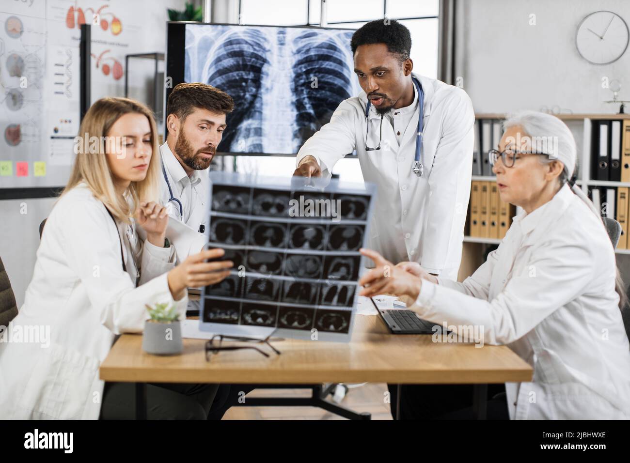 Multiracial male and female doctors having briefing at clinic for ...