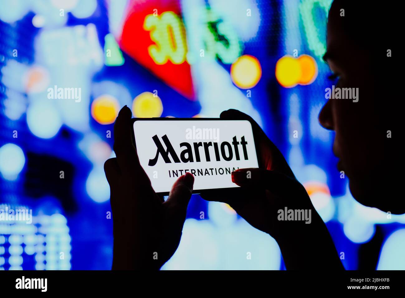 In this photo illustration, a silhouetted woman holds a smartphone with ...