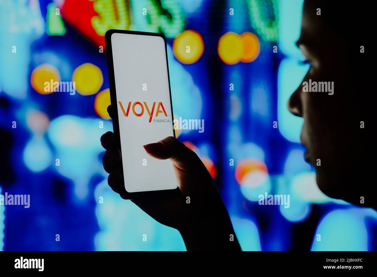 In this photo illustration, a silhouetted woman holds a smartphone with ...