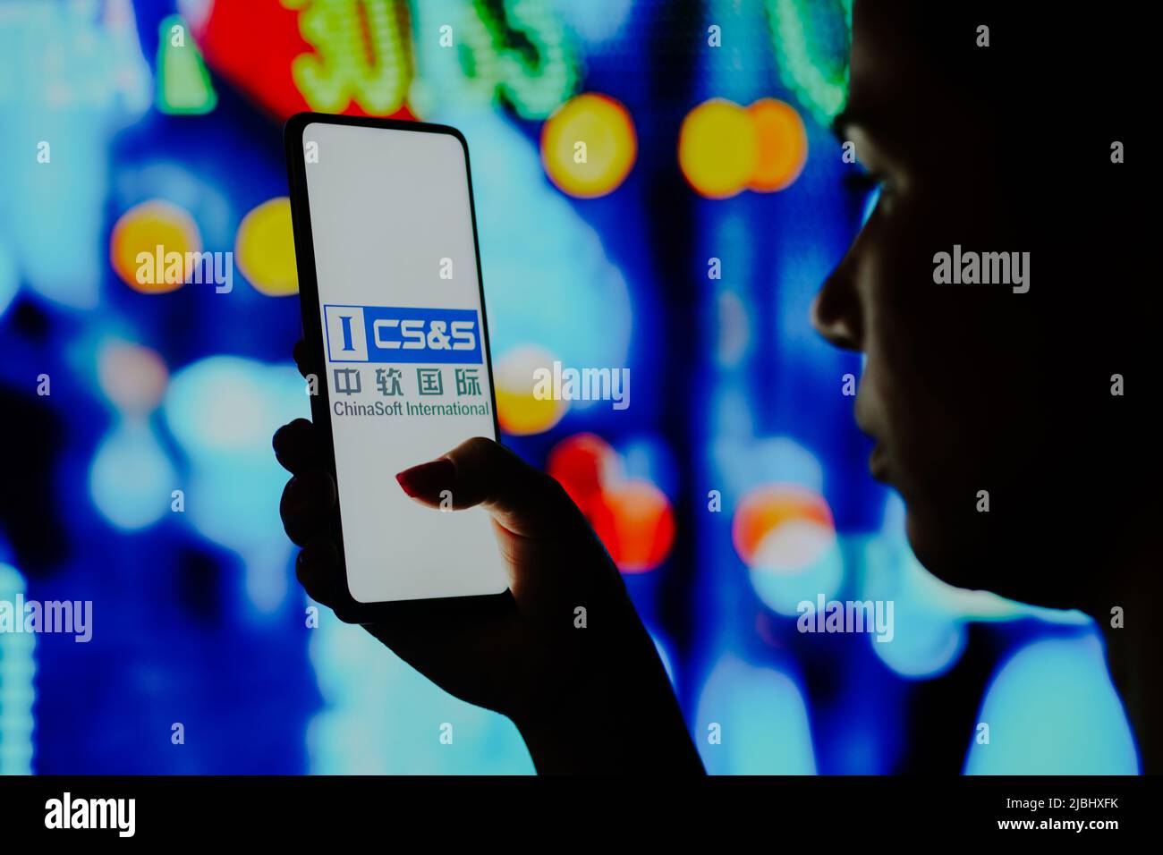In this photo illustration, a silhouetted woman holds a smartphone with ...