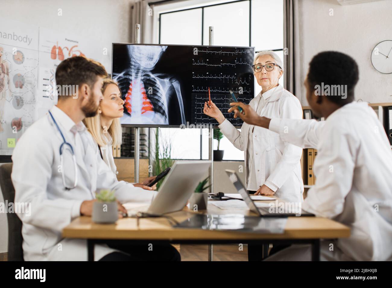 Team of competent medical specialists gathering at boardroom for ...