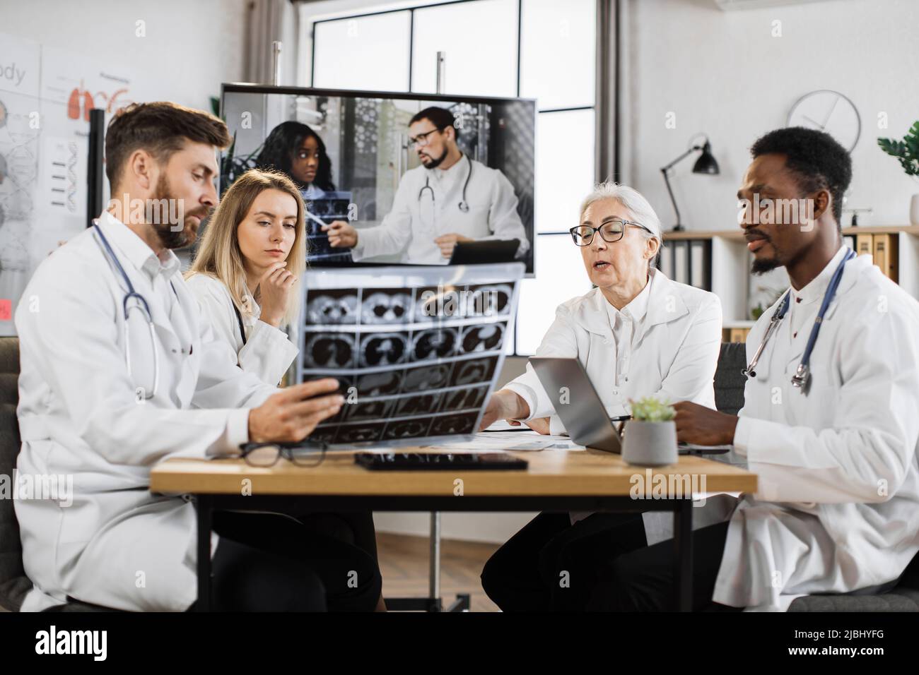 Group of multiethnic medical researchers having distant video webinar ...