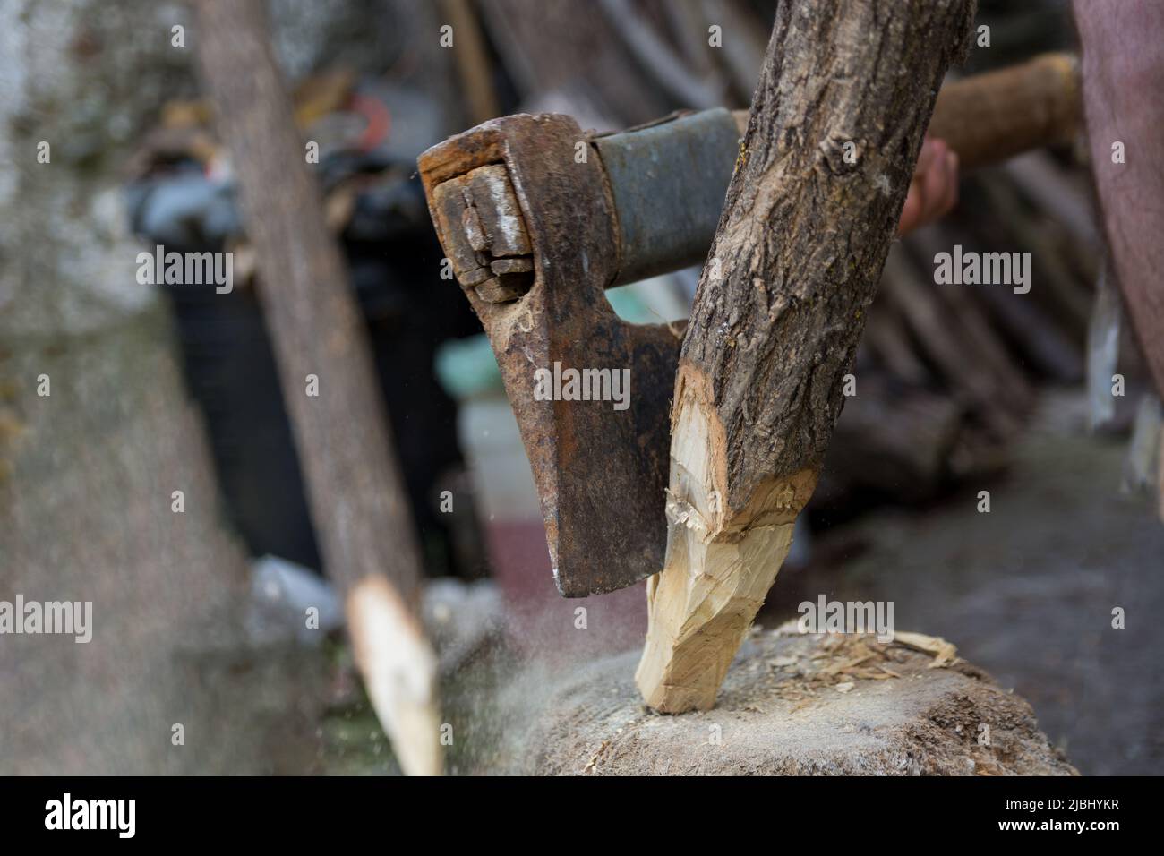 Ax cutting wooden stake outdoor in village yard. Close up, selective ...