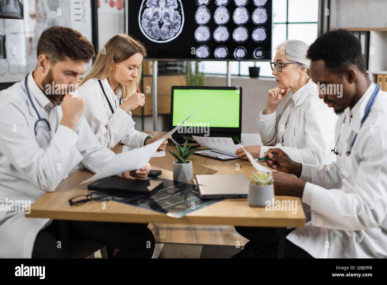 Group of four pensive medical worker looking at patient presription and ...
