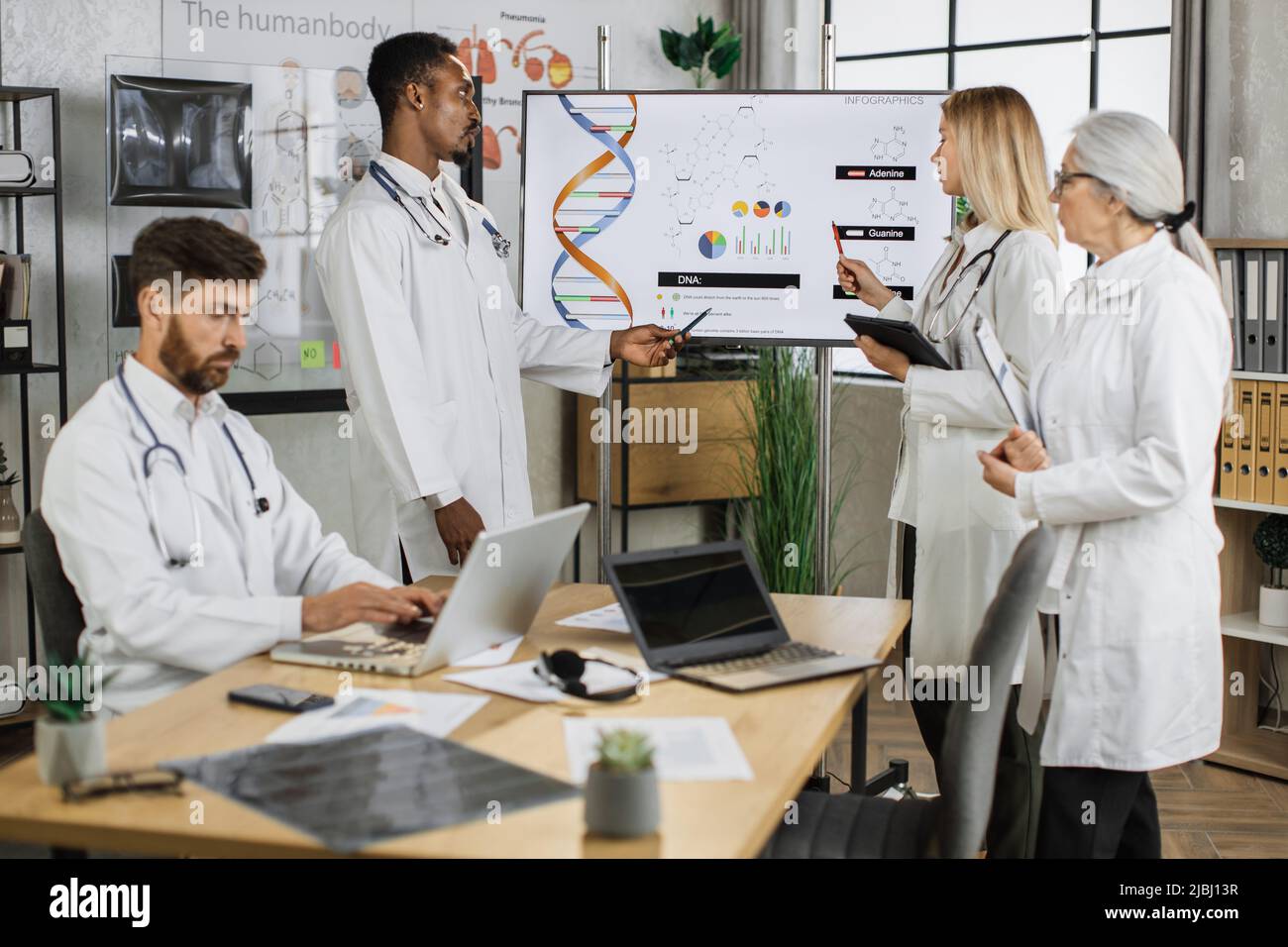 Group of multicultural medical workers discussing gene modification ...