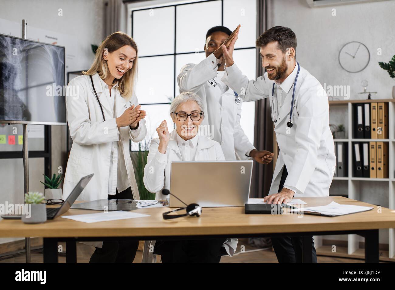 Team of smiling multicultural doctors clapping hands and giving high ...