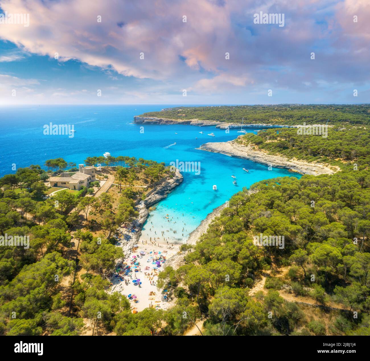 Aerial view of sandy beach with colorful umbrellas, green forest Stock ...