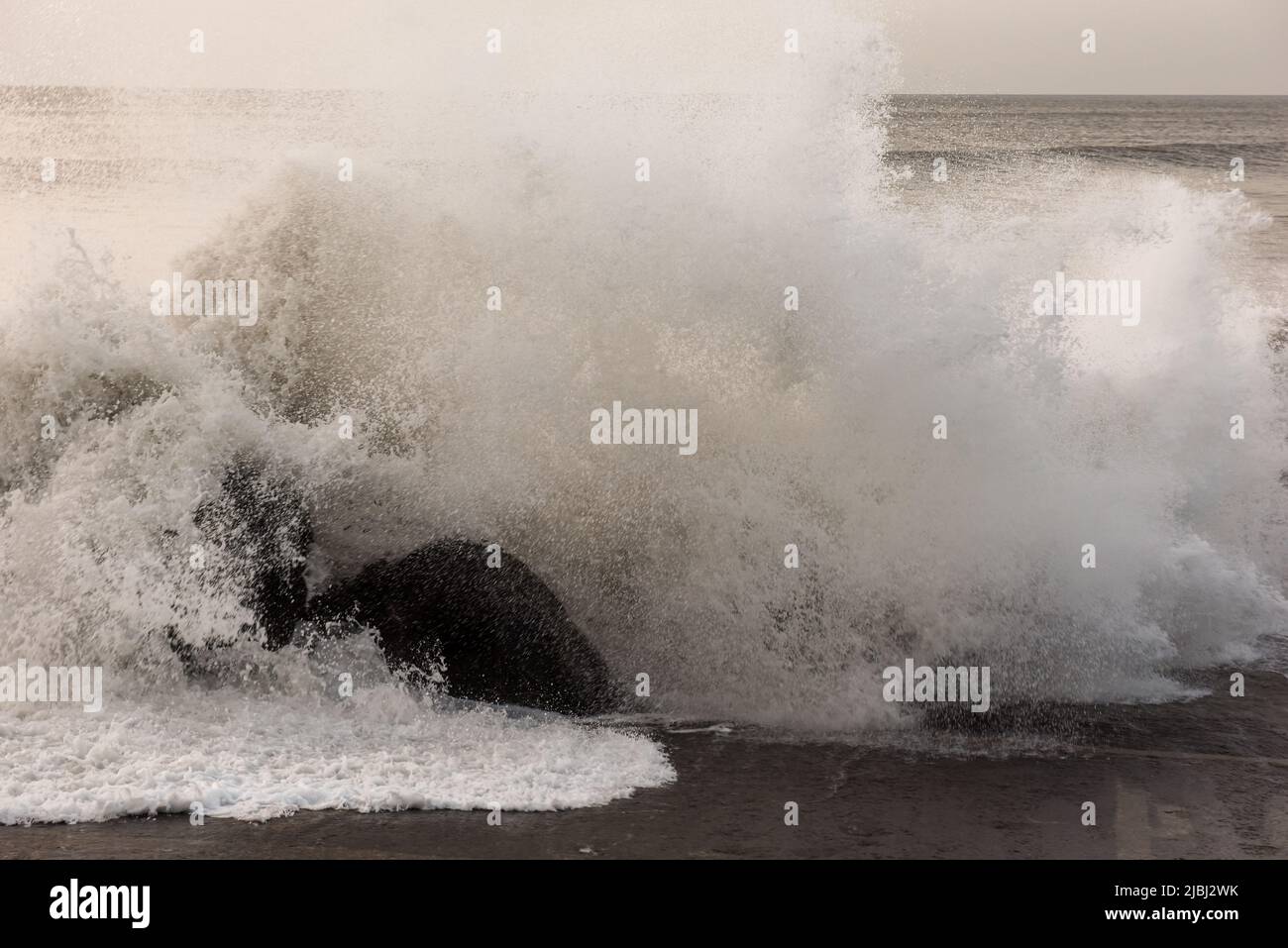 Breaking waves crashing over rocks on the sea shore Stock Photo - Alamy