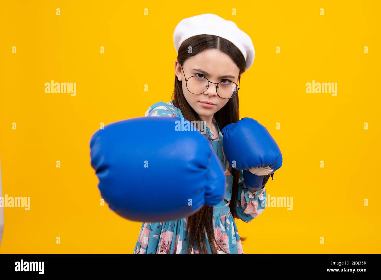 Portrait of a cute teenage boxer girl on yellow isolated background ...