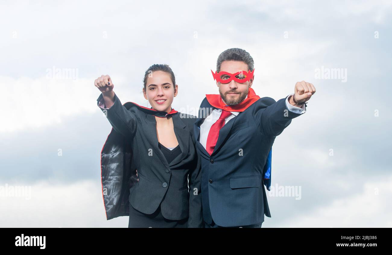 smiling business couple in superhero suit on sky background Stock Photo ...