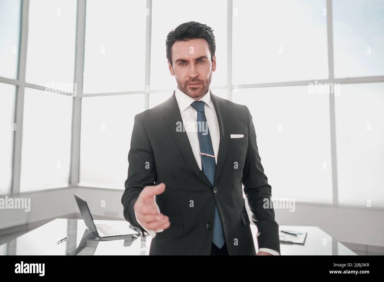 confident businessman reaching out for a handshake Stock Photo - Alamy