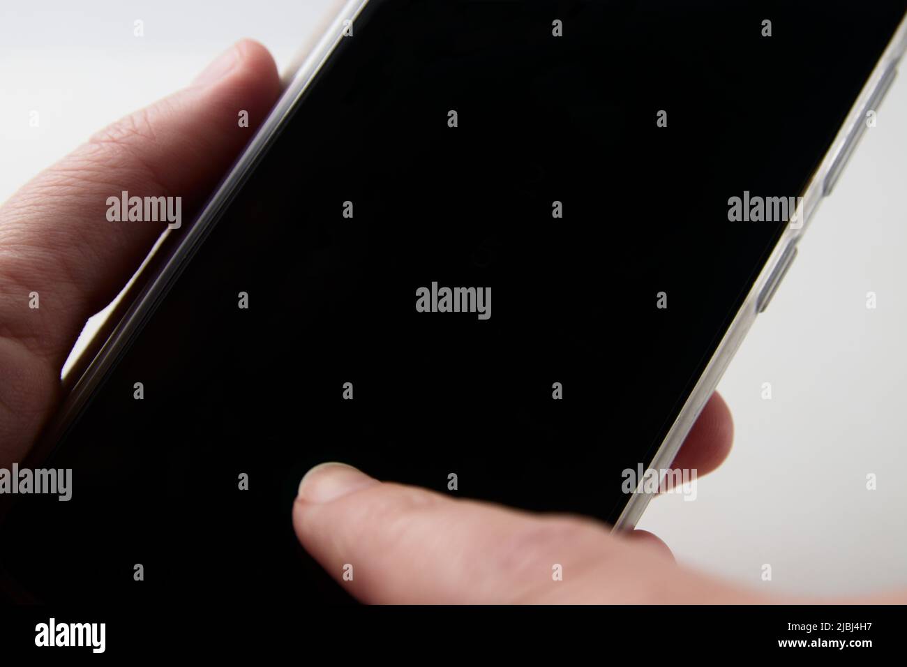 A woman holding and tapping the screen of a smartphone with the screen ...