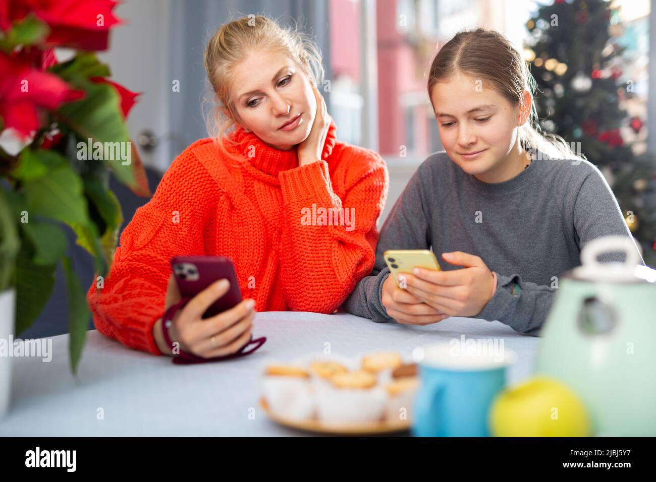 Woman and her daughter playing on smartphones Stock Photo - Alamy