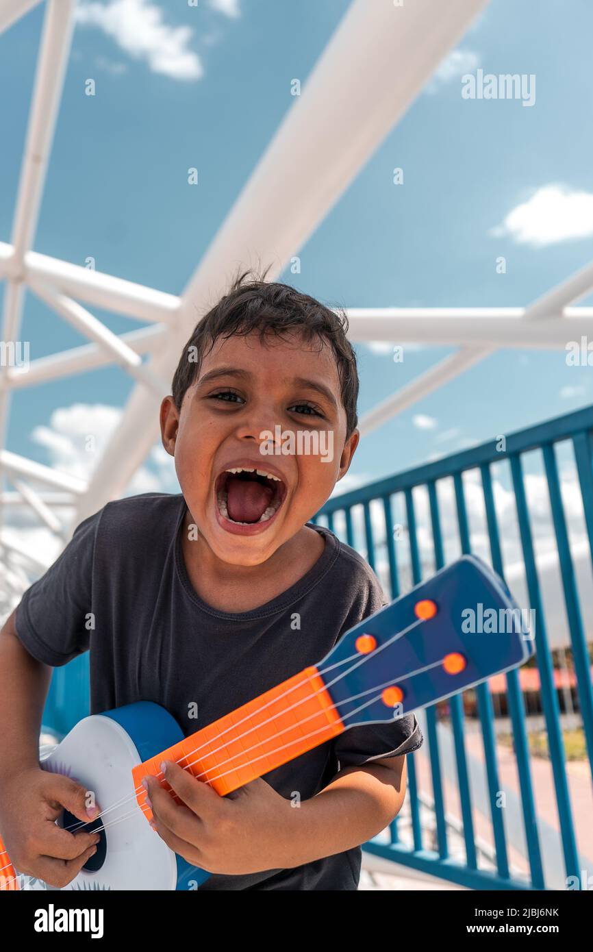 Latin boy playing the ukulele and dreaming of being a rock star Stock ...