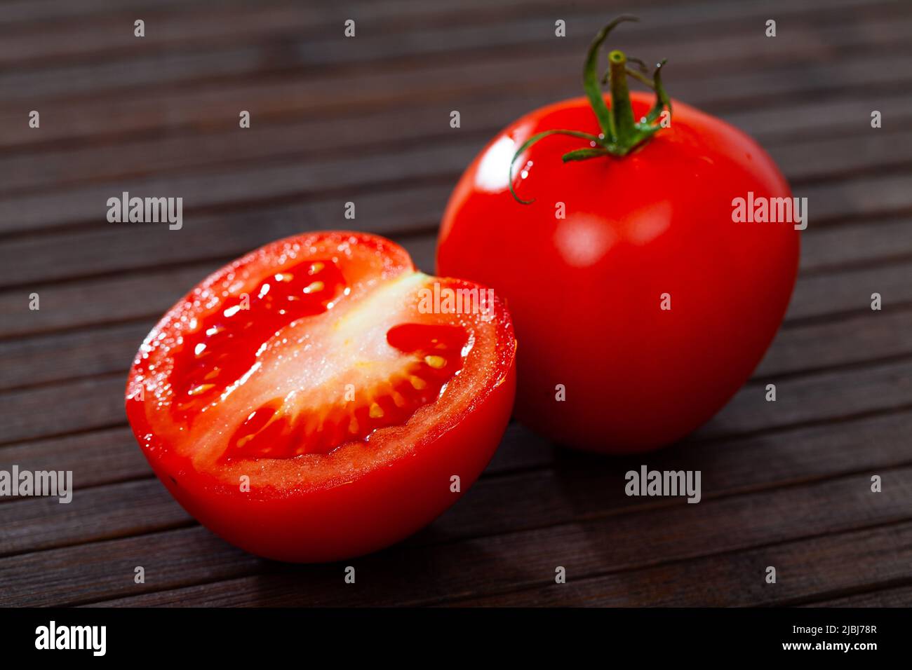 Two red tomatoes on wooden table Stock Photo - Alamy