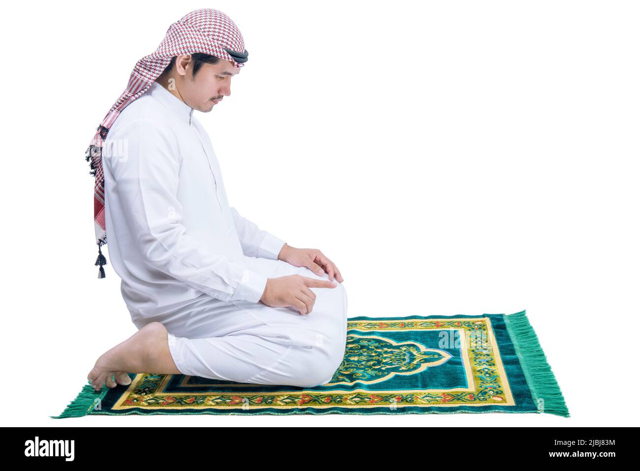 Muslim man with keffiyeh with agal in praying position (salat) on the ...
