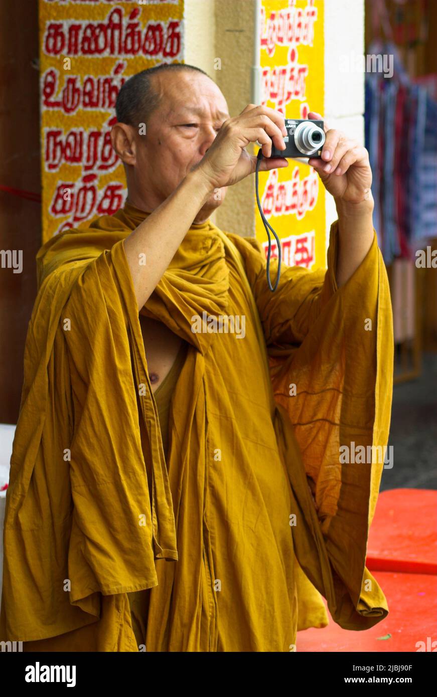 A saffron-robed Buddhist monk as tourist, Singapore Stock Photo - Alamy