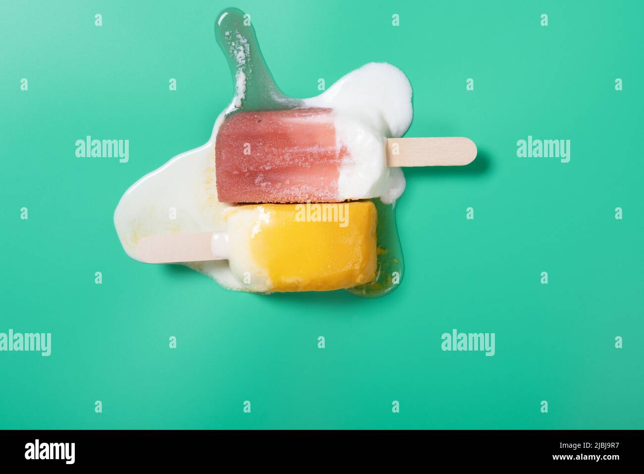 top view two vibrant color popsicles melting on green background Stock ...