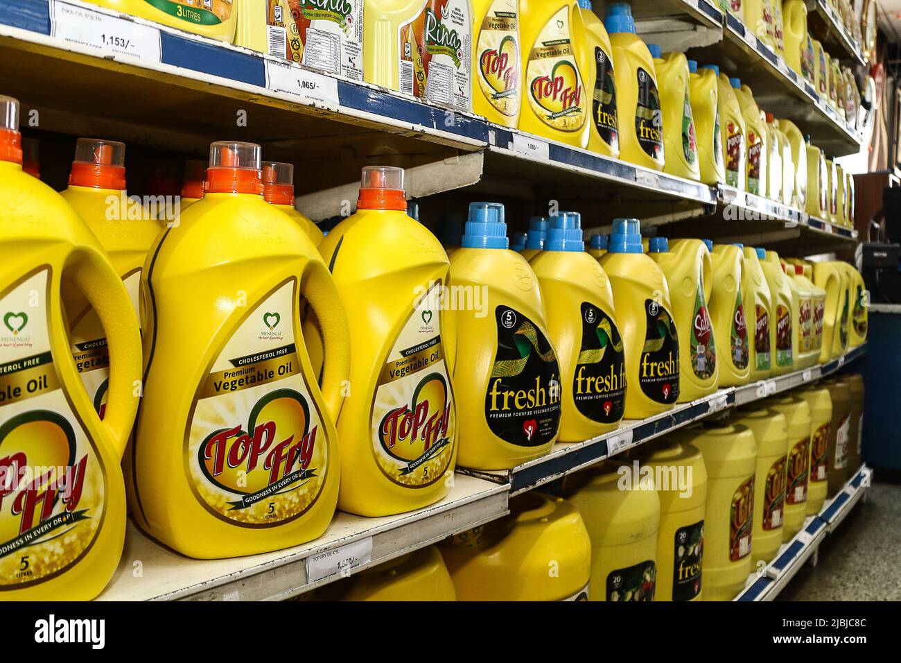 Plastic bottles of vegetable oil seen on a shelf at a local supermarket ...