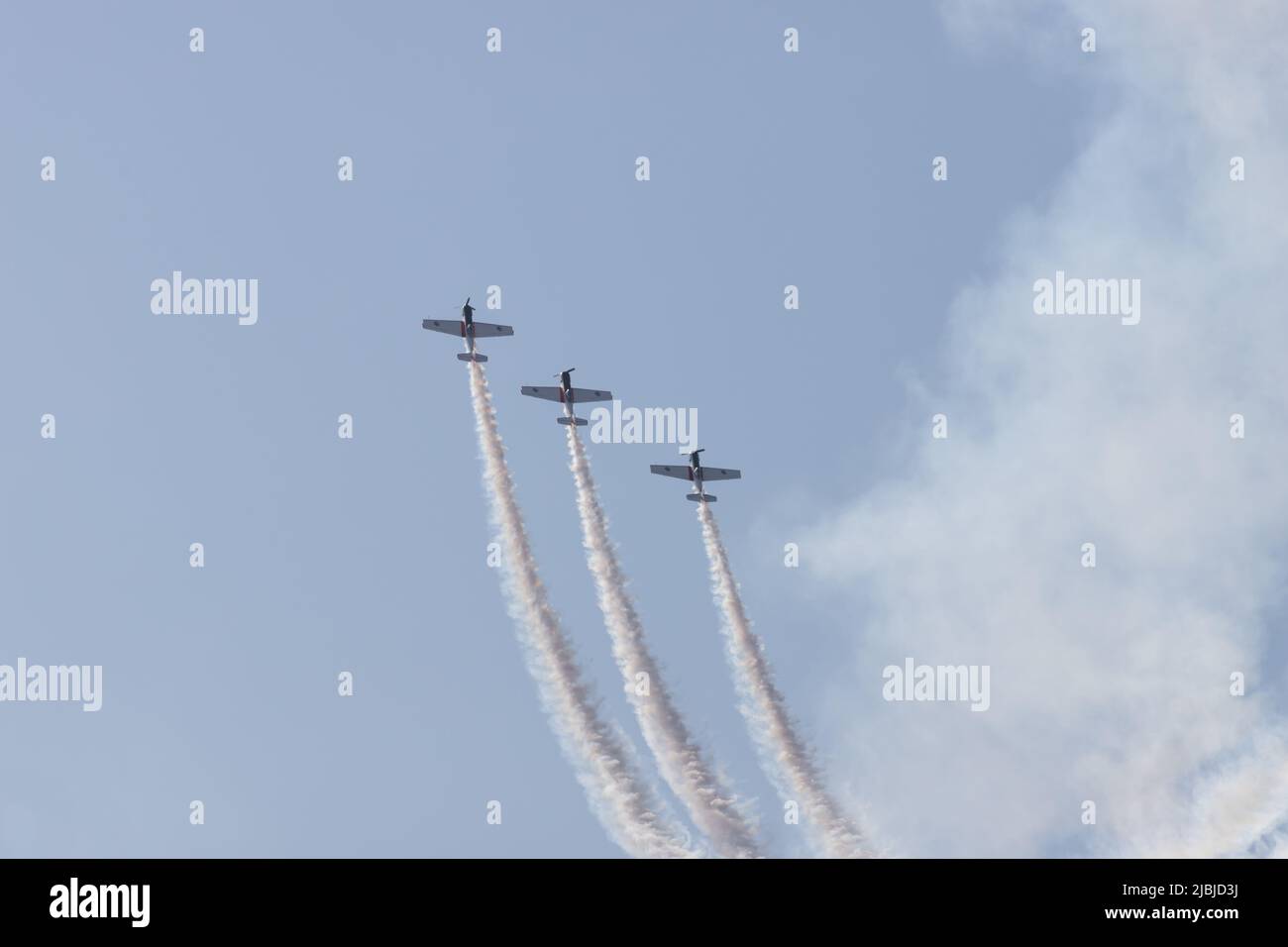Three colorful jets flying up in the blue sky and performing a show ...
