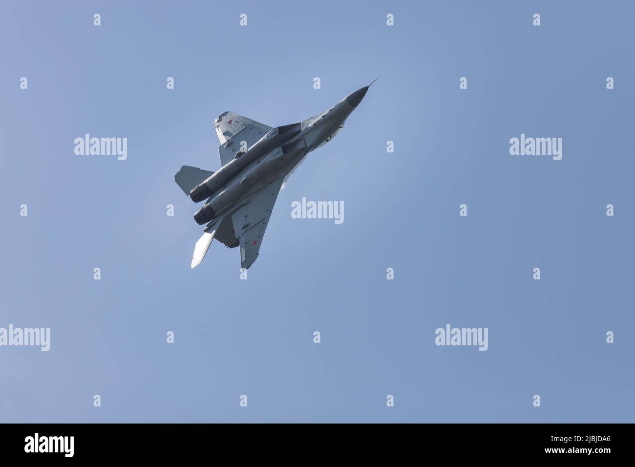 A military fighter jet with red stars on the wings flying in the sky ...