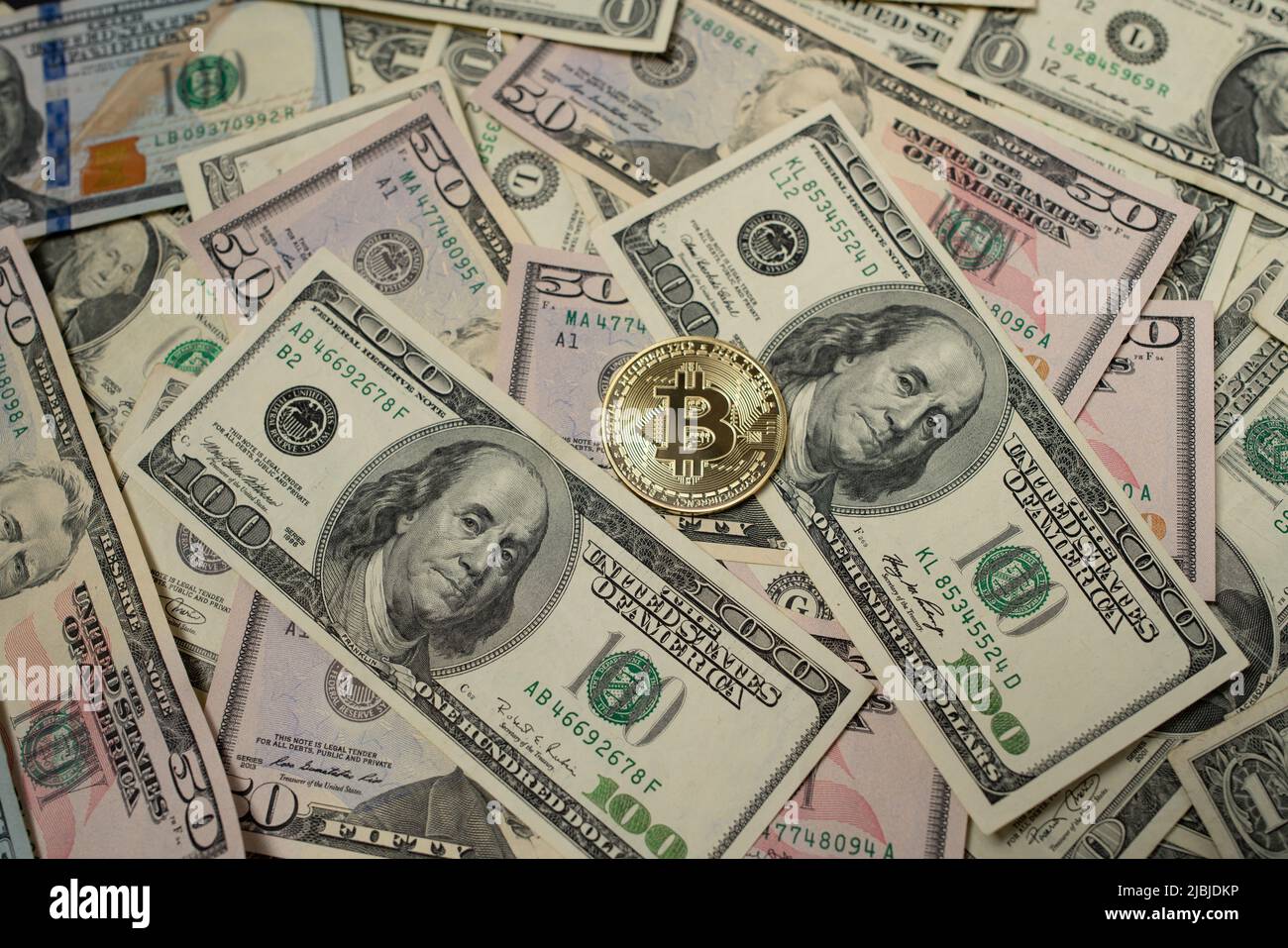 Bitcoin gold coin on top of one hundred dollar banknote. US dollar ...
