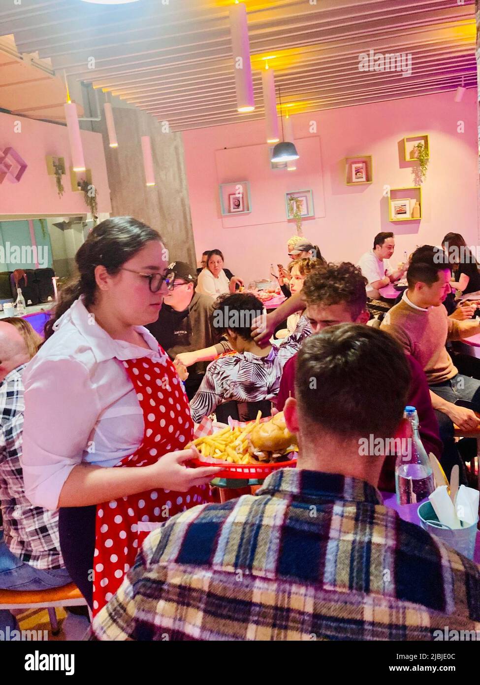Sydney, Australia. 25th May, 2022. A slightly annoyed waitress in a red ...