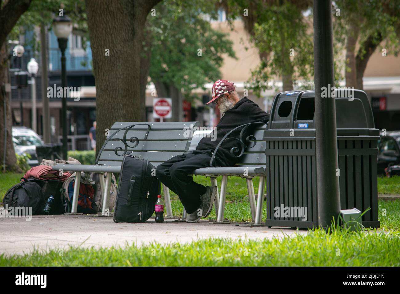 sad lonely homeless man sitting on park bench Stock Photo - Alamy