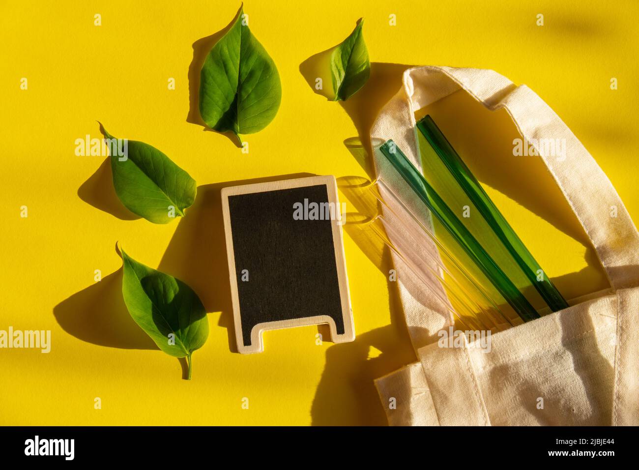 Reusable glass Straws on colorful background with green leafs in eco ...