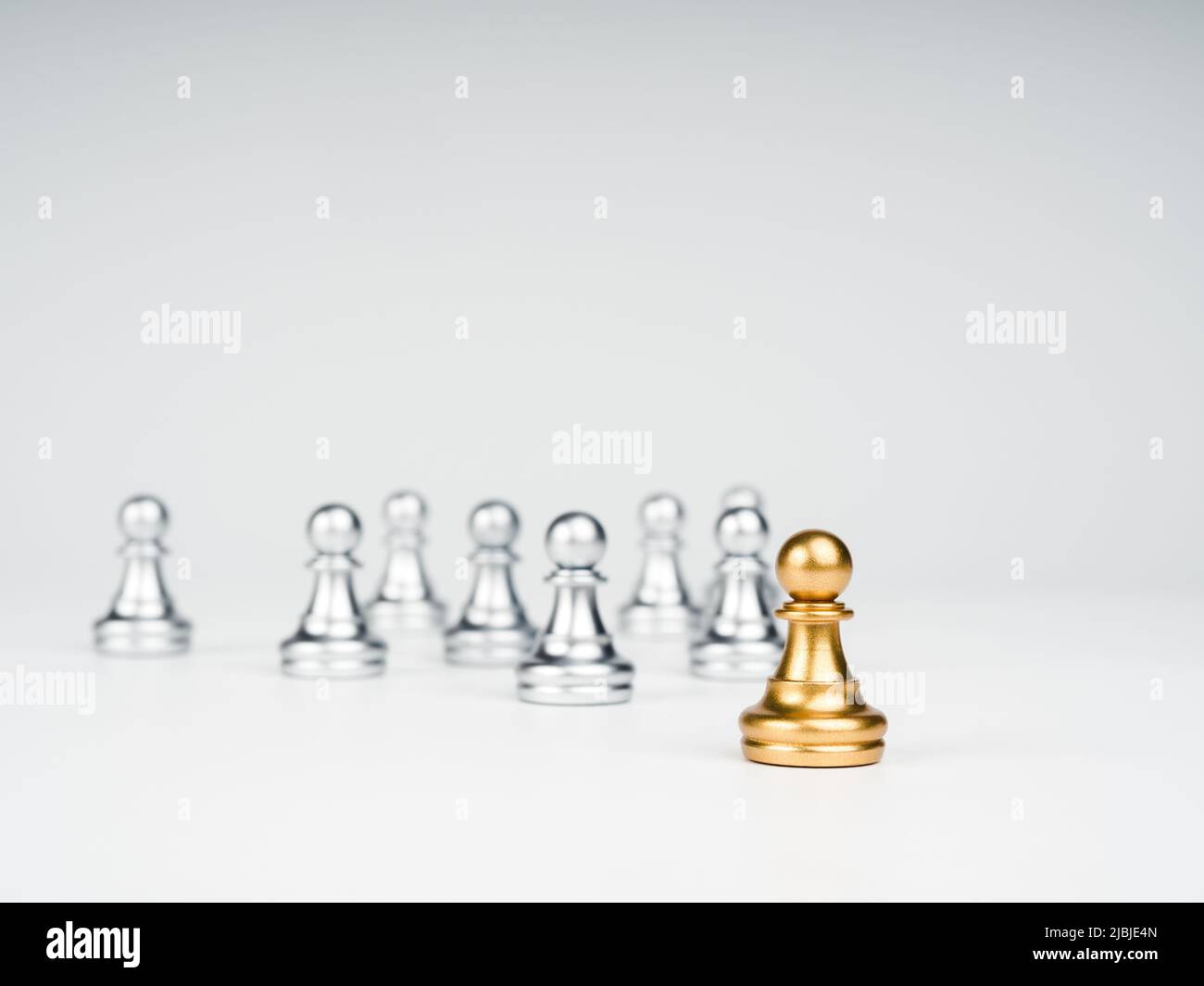 The golden pawn chess piece standing out from the group of silver pawn ...