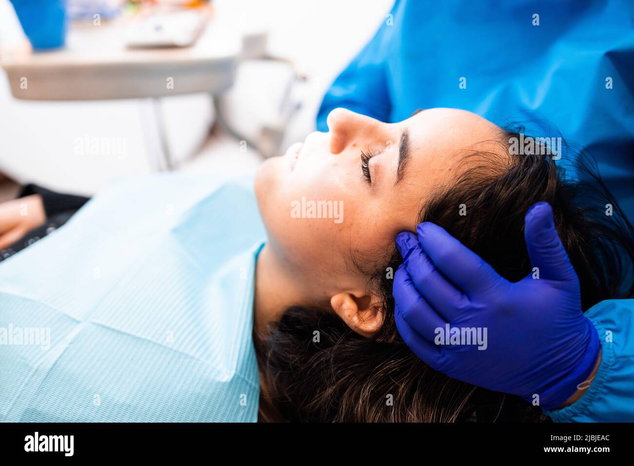 Unrecognizable dentist doing a palpation at the temporalis muscle. Exam ...