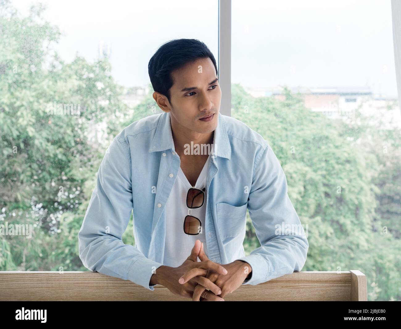 Portrait of thoughtful Asian man feeling lonely looking away and ...