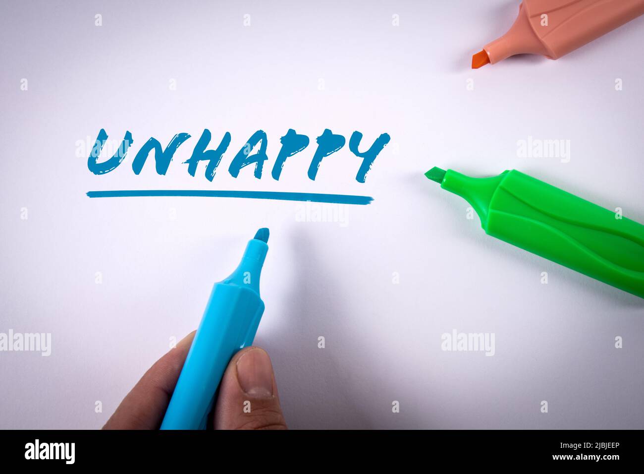 Unhappy. Text and colored markers on a white background Stock Photo - Alamy