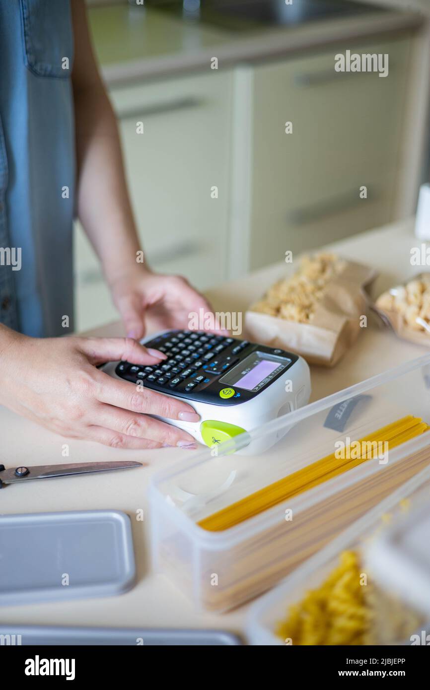 Housewife typing names of pasta kinds use label machine device food ...
